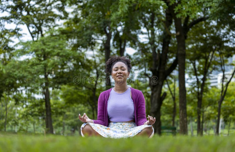 African American Woman Relaxingly Practicing Meditation In The Forest