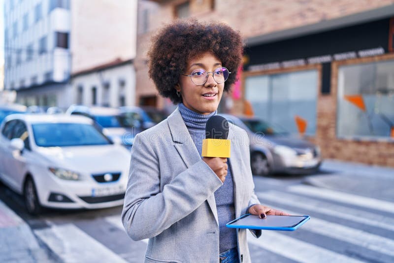 African American Woman Reporter Working Using Microphone and Touchpad ...