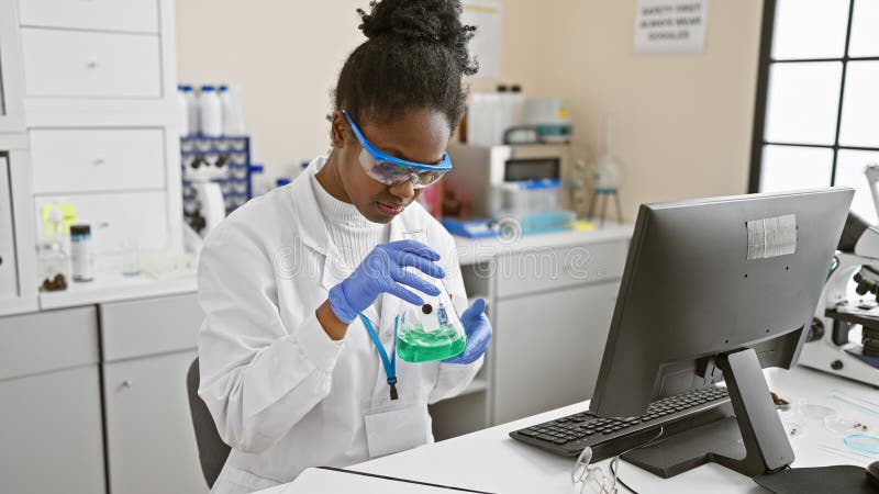 African American Woman Scientist Analyzes Green Solution in Laboratory ...