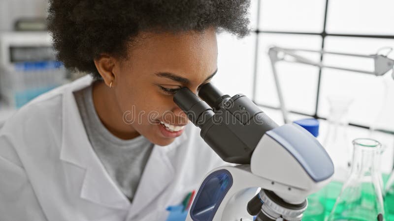 African American Woman Scientist Using Microscope in Laboratory Setting ...