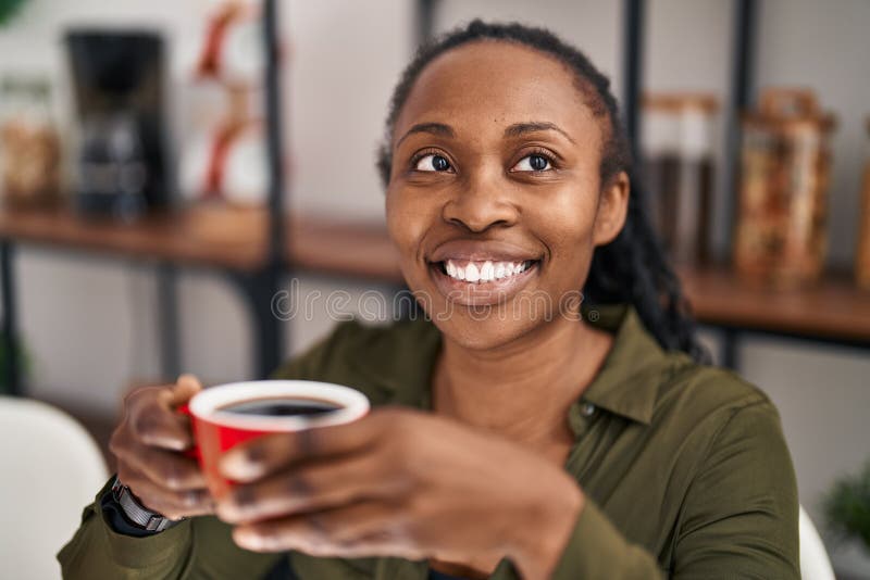 African American Woman Smiling Confident Drinking Coffee At Home Stock
