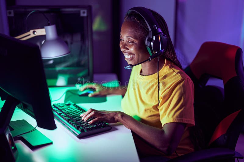 African American Woman Streamer Playing Video Game Using Computer at ...
