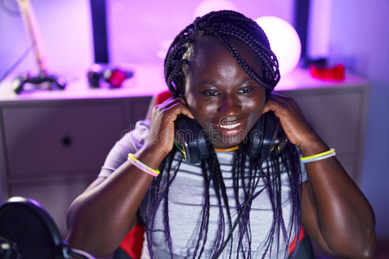 African American Woman Streamer Smiling Confident Sitting on Table at ... African American Woman Streamer Smiling Confident Sitting on Table at ...