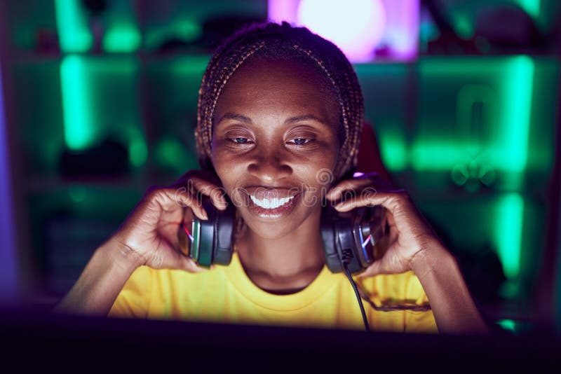African American Woman Streamer Smiling Confident Sitting on Table at ... African American Woman Streamer Smiling Confident Sitting on Table at ...