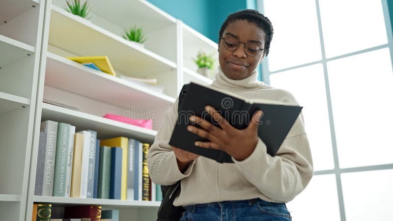 African American Woman Student Standing Reading Book at Library ...