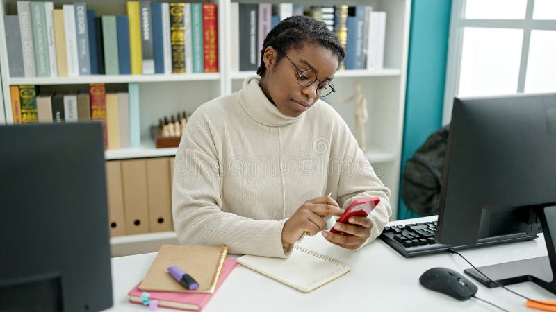 African American Woman Student Using Computer and Smartphone at Library ...