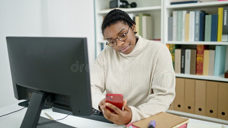 African American Woman Student Using Computer and Smartphone at Library ...