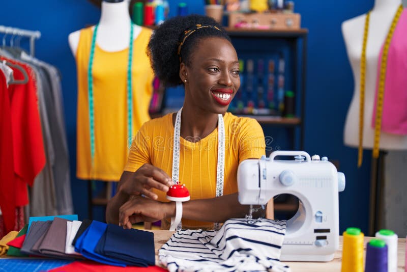African American Woman Tailor Using Sewing Machine Holding Pin at ...