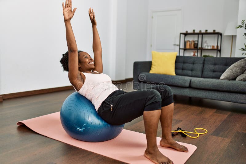 African American Woman Training Abs Exercise Using Fit Ball at Home ...