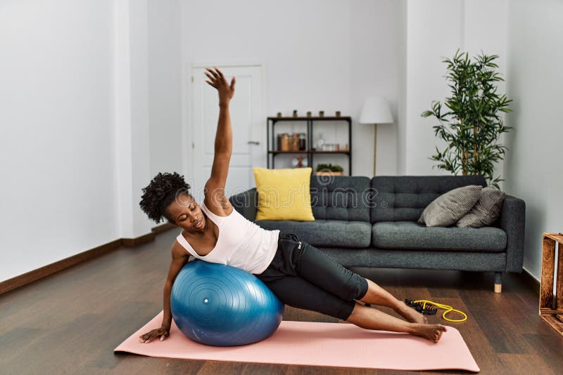 African American Woman Training Abs Exercise Using Fit Ball at Home ...