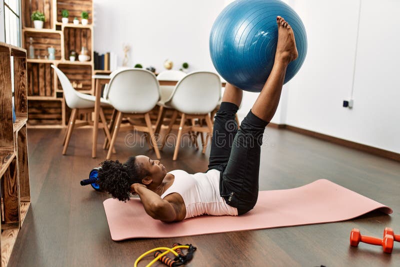 African American Woman Training Abs Exercise Using Fit Ball at Home ...