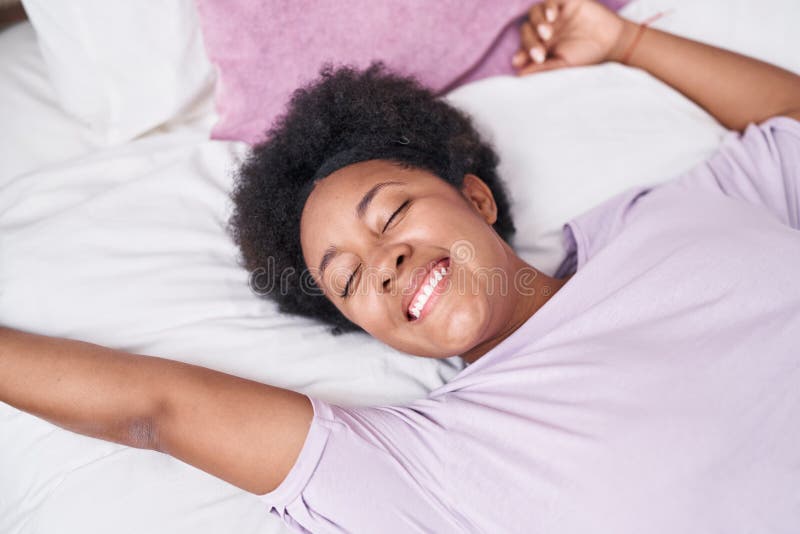 African American Woman Waking Up Stretching Arms At Bedroom Stock Image