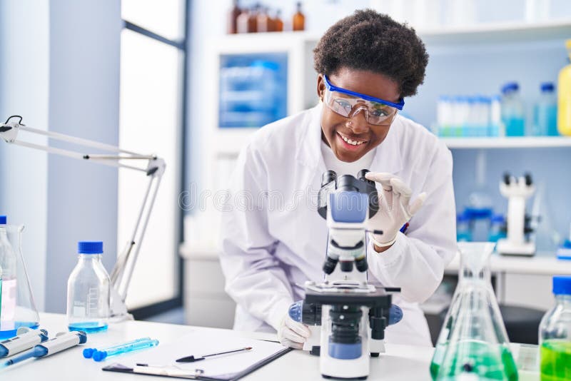 African American Woman Wearing Scientist Uniform Using Microscope at ...