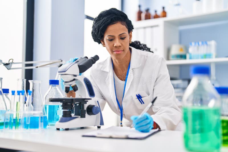 African American Woman Wearing Scientist Uniform Using Microscope Write ...
