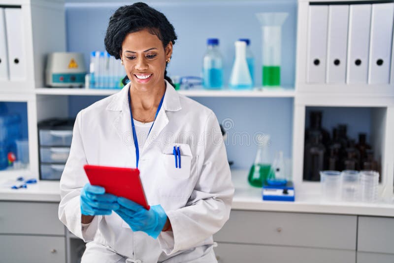 African American Woman Wearing Scientist Uniform Using Touchpad at ...