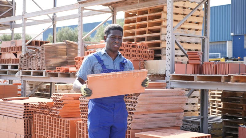 African American Worker Stacking Bricks in Warehouse of Building ...