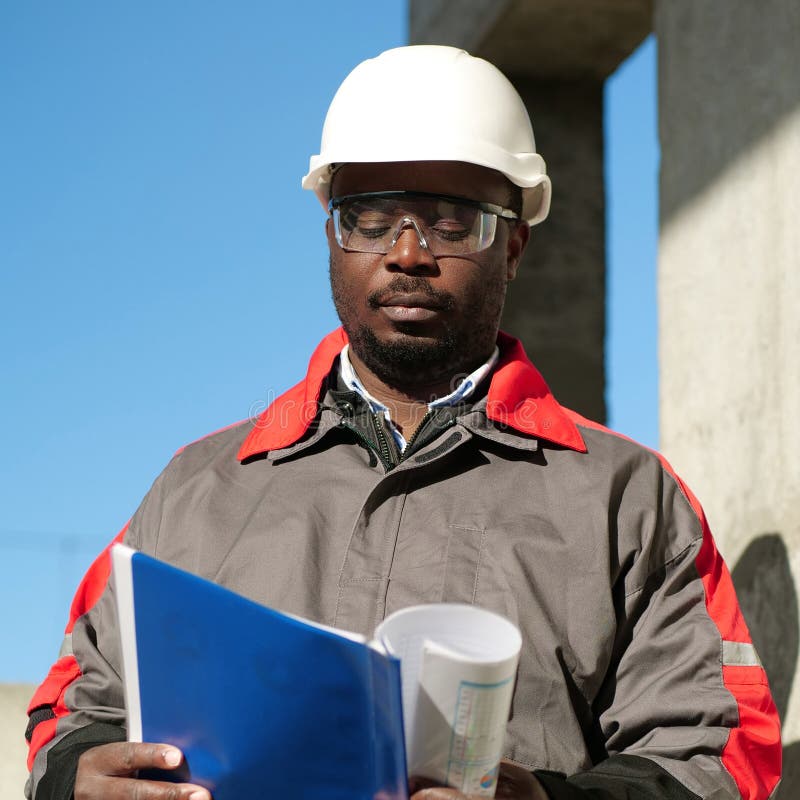 African American Worker Stands at Construction Site with Work Papers ...