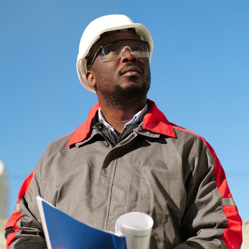 African American Worker Stands at Construction Site with Work Papers ...