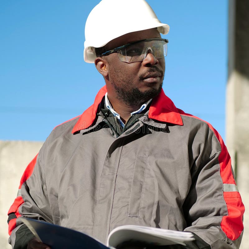 African American Worker Stands at Construction Site with Work Papers ...