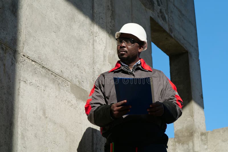 African American Workman at Construction Site with Work Papers Stock ...