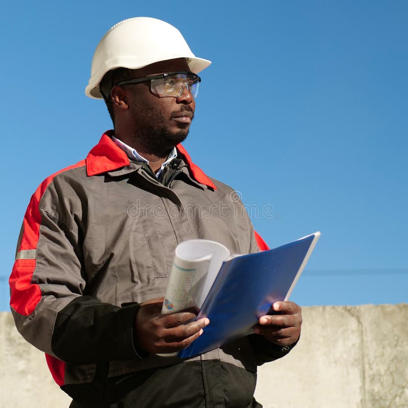 African American Worker Stands at Construction Site with Work Papers ...
