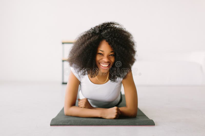 An African American Young Woman Doing Physical Exercises in a Mat Stock ...