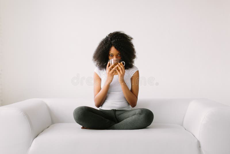 An African American Young Women Sitting In The Lotus Position On White