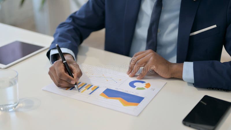 African Businessman Reading Charts on Paper, Paperwork Stock Image ...