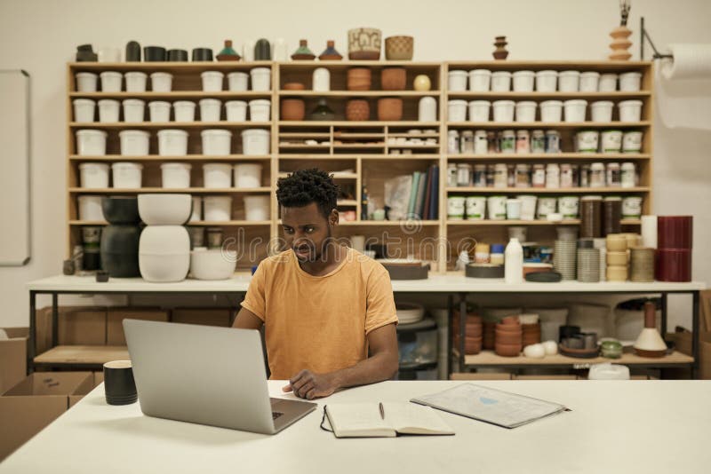 African Ceramics Workshop Manager Using a Laptop in a Studio Stock ...