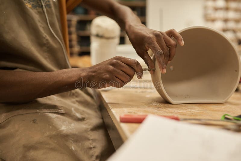African Ceramist Making Holes in a Pot at a Workbench in a Studio Stock ...