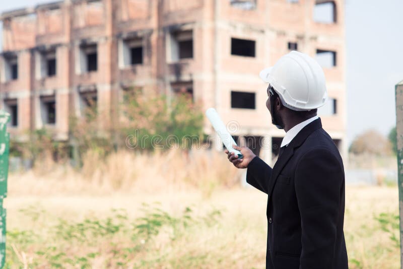 African Engineering Man Stand Up and Holding Tablet with Building ...