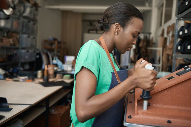 African Female Leather Worker Using a Cutting Machine Stock Photo ...