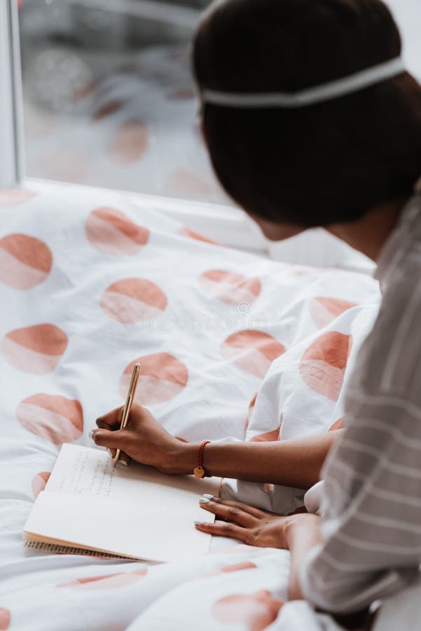 African Female Writing Notes in a Diary while Sitting on the Bed Stock ...
