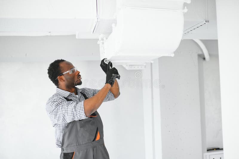 African HVAC Technician Worker Testing Newly Installed Ventilation ...