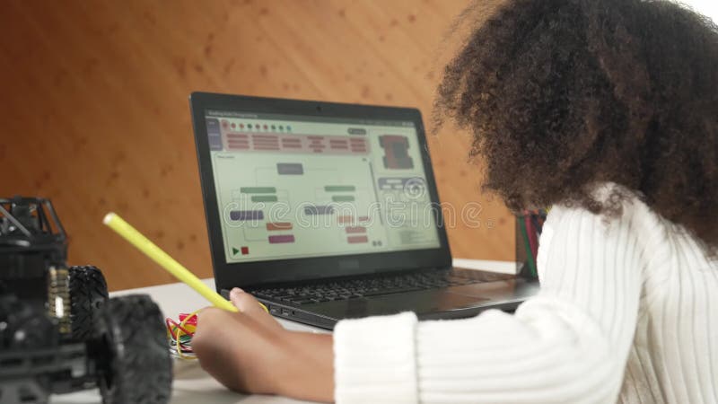 African Kid Writing or Car Model Structure while Laptop Display Code ...