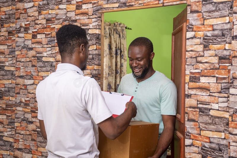 African Male Receiving a Parcel from a Delivery Service Worker Stock ...