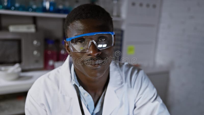 African Male Scientist Wearing Lab Coat and Protective Goggles in a ...