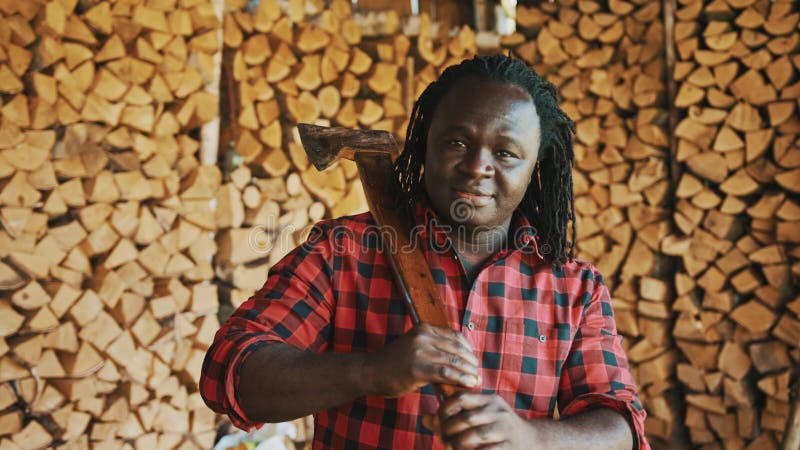 African Man with the Axe Standing in Front of Stack of Cutted Timber ...
