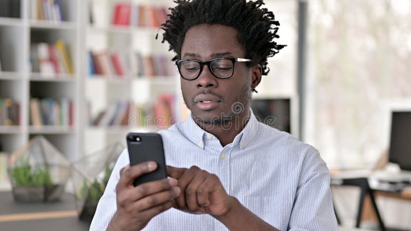 African Man Browsing Internet on Smartphone Stock Image - Image of ...