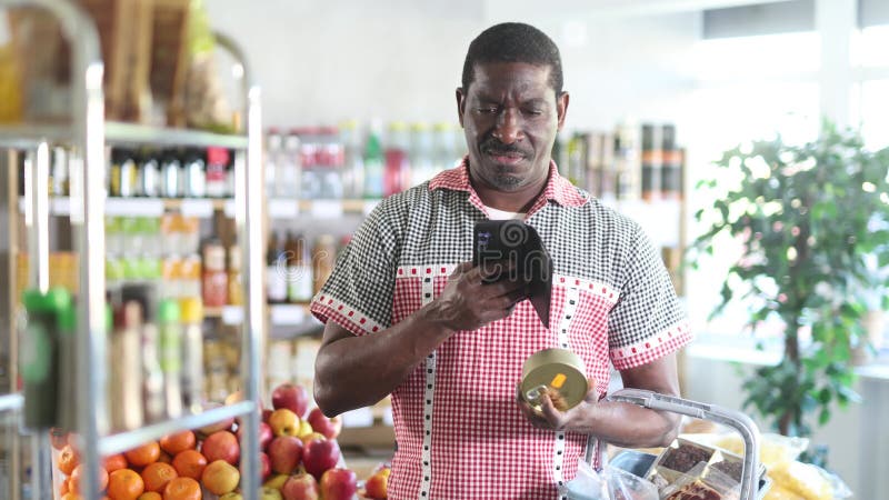 African Man Customer at Shop Scans QR Code on Tin Cans of Preserves ...