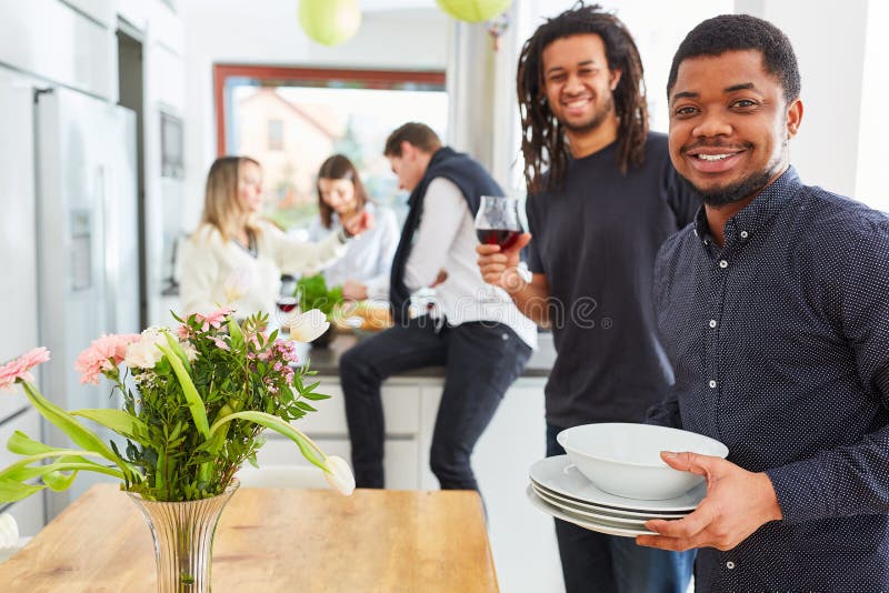 African Man with Dishes at Table Setting in Kitchen Stock Image - Image ...