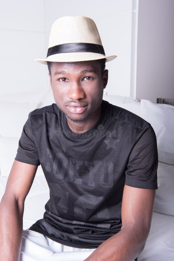 African Man with Hat Sitting on Couch Stock Image - Image of cool ...