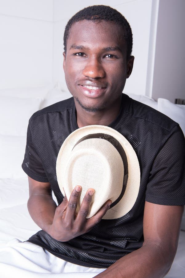 African Man with Hat Sitting on Couch Stock Photo - Image of person ...