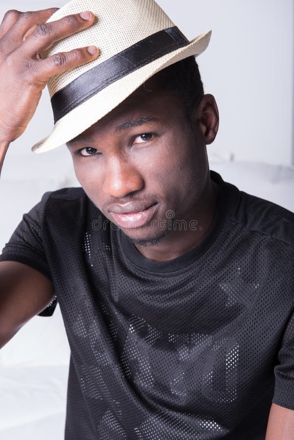 African Man with Hat Sitting on Couch Stock Photo - Image of side ...
