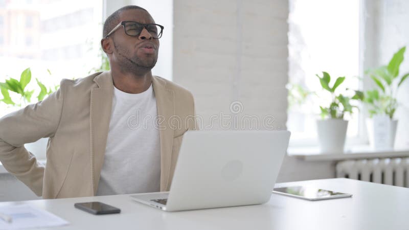 African Man Having Back Pain while Using Laptop in Office Stock Image ...