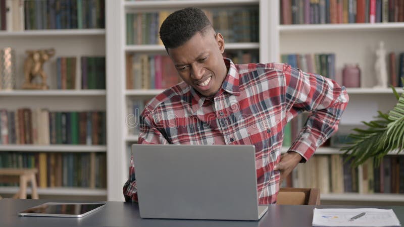 African Man Having Back Pain while Using Laptop in Office Stock Photo ...