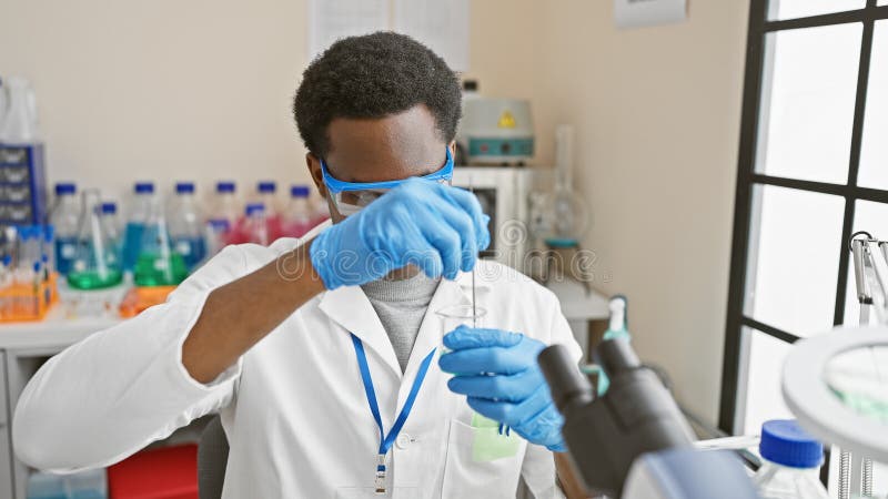 African Man Scientist Working Diligently with a Test Tube in a Modern ...