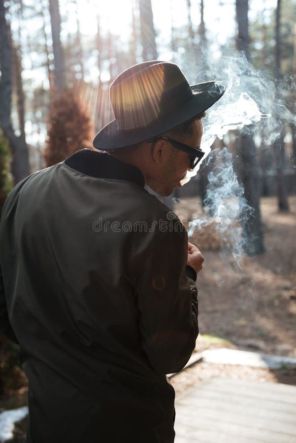 African Man Standing Outdoors in the Forest Smoking. Stock Photo ...