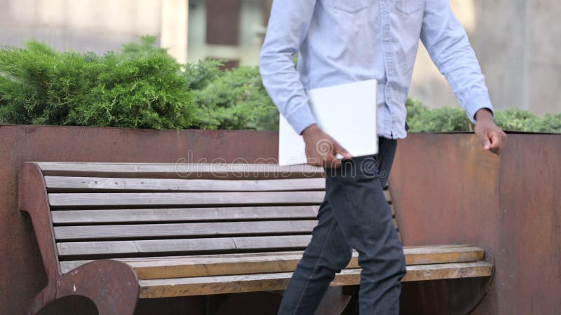 African Man Standing Up and Going Away from Outdoor Bench Stock Image ...