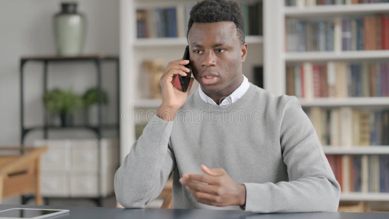 African Man Talking on Phone in Library Stock Image - Image of talking ...